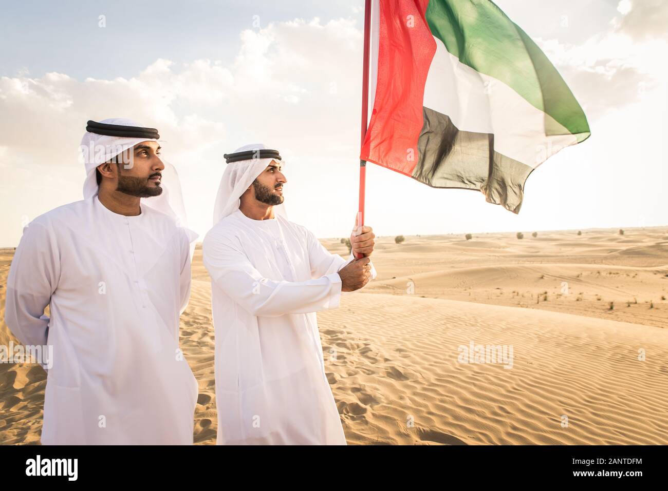 Arabian men witk kandora walking in the desert - Portrait of two middle ...