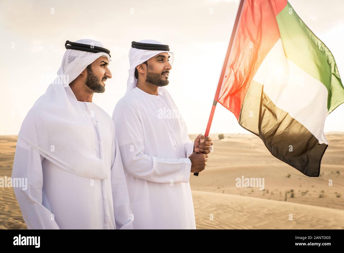Arabian men witk kandora walking in the desert - Portrait of two middle ...