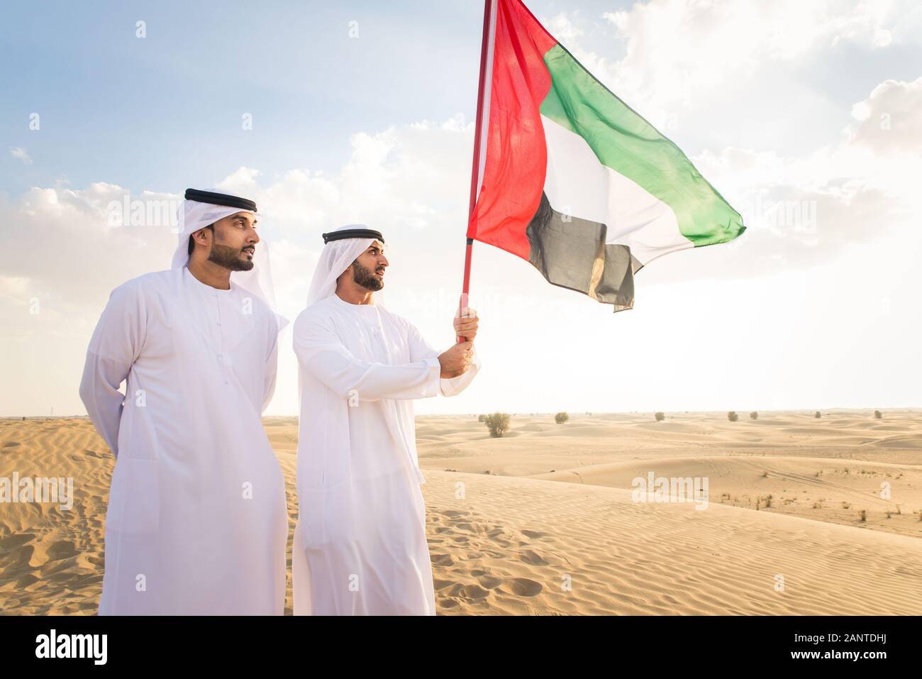 Arabian men witk kandora walking in the desert - Portrait of two middle ...