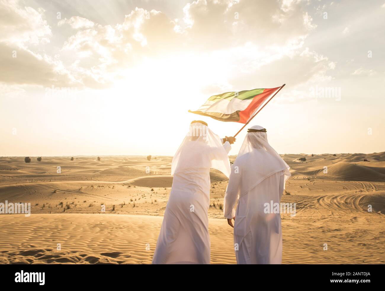 Arabian men witk kandora walking in the desert - Portrait of two middle ...