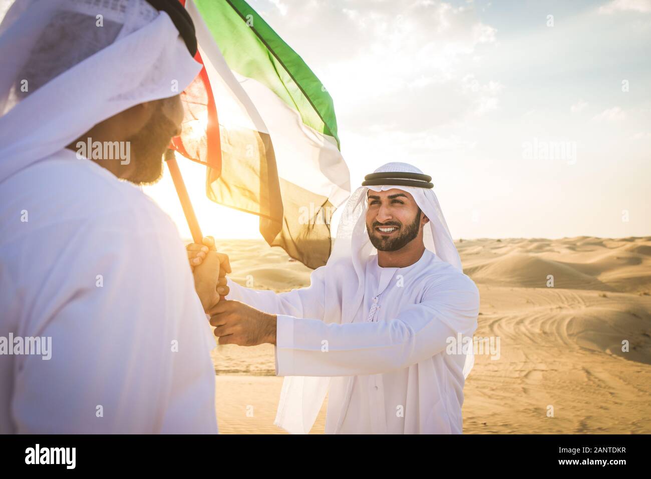 Arabian men witk kandora walking in the desert - Portrait of two middle ...