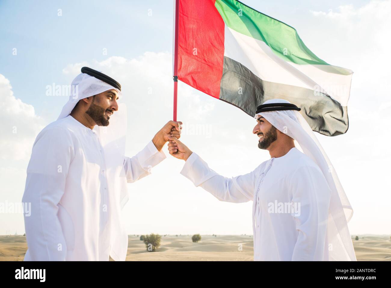 Arabian men witk kandora walking in the desert - Portrait of two middle ...