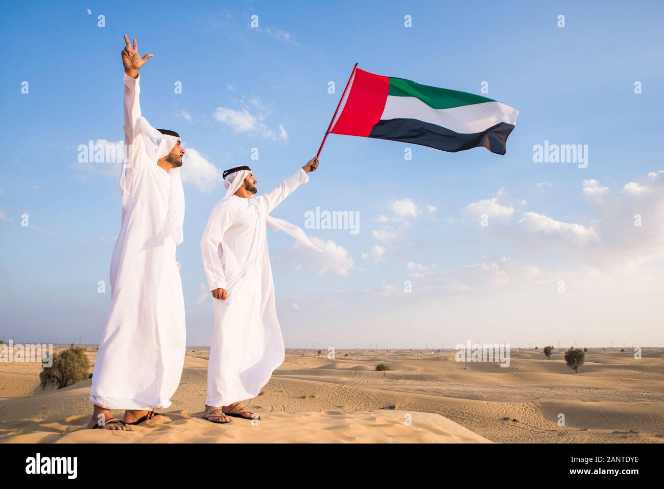 Arabian men witk kandora walking in the desert - Portrait of two middle ...