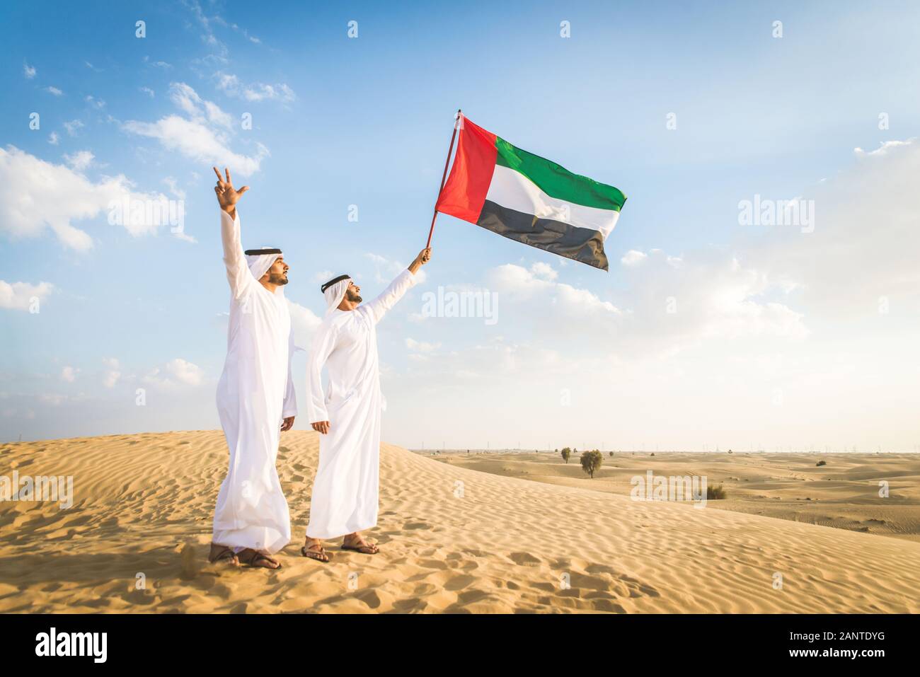 Arabian men witk kandora walking in the desert - Portrait of two middle ...