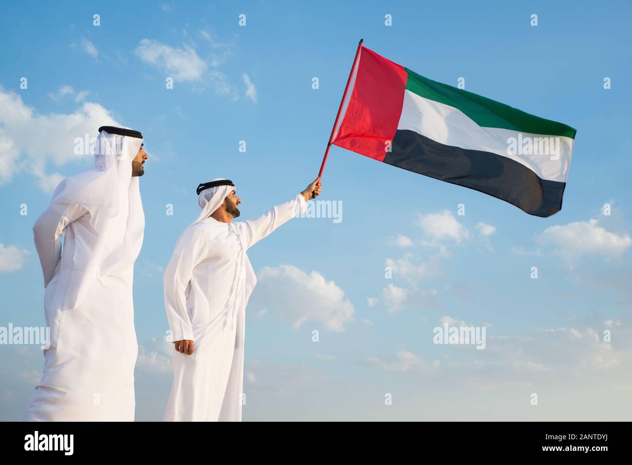 Arabian men witk kandora walking in the desert - Portrait of two middle ...