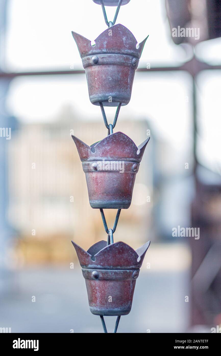 Ornamental cast metal water cup on a traditional Japanese rain chain ...
