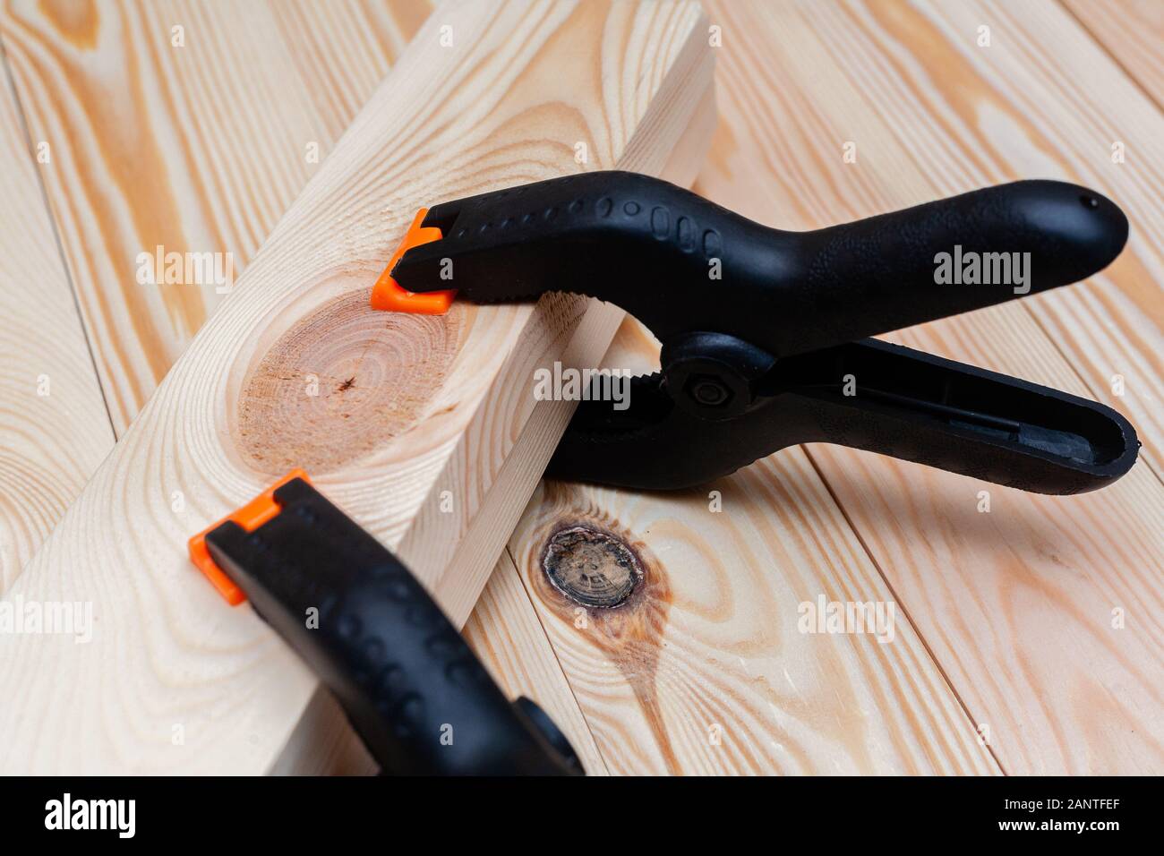 Black plastic clamp on a wooden background Stock Photo - Alamy