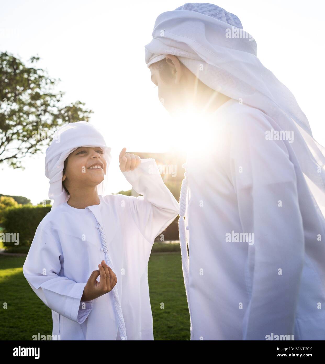 Group of middle-eastern kids wearing white kandora playing in a park in ...
