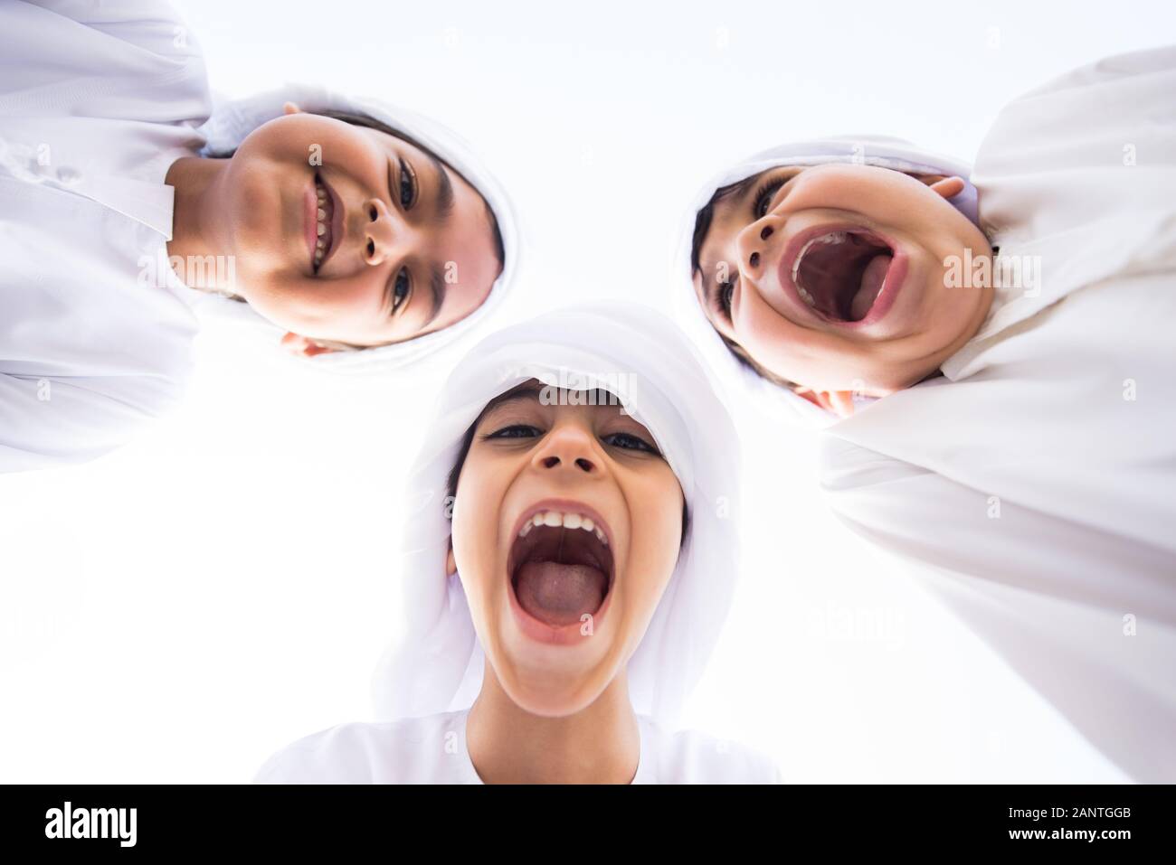 Group of middle-eastern kids wearing white kandora playing in a park in ...
