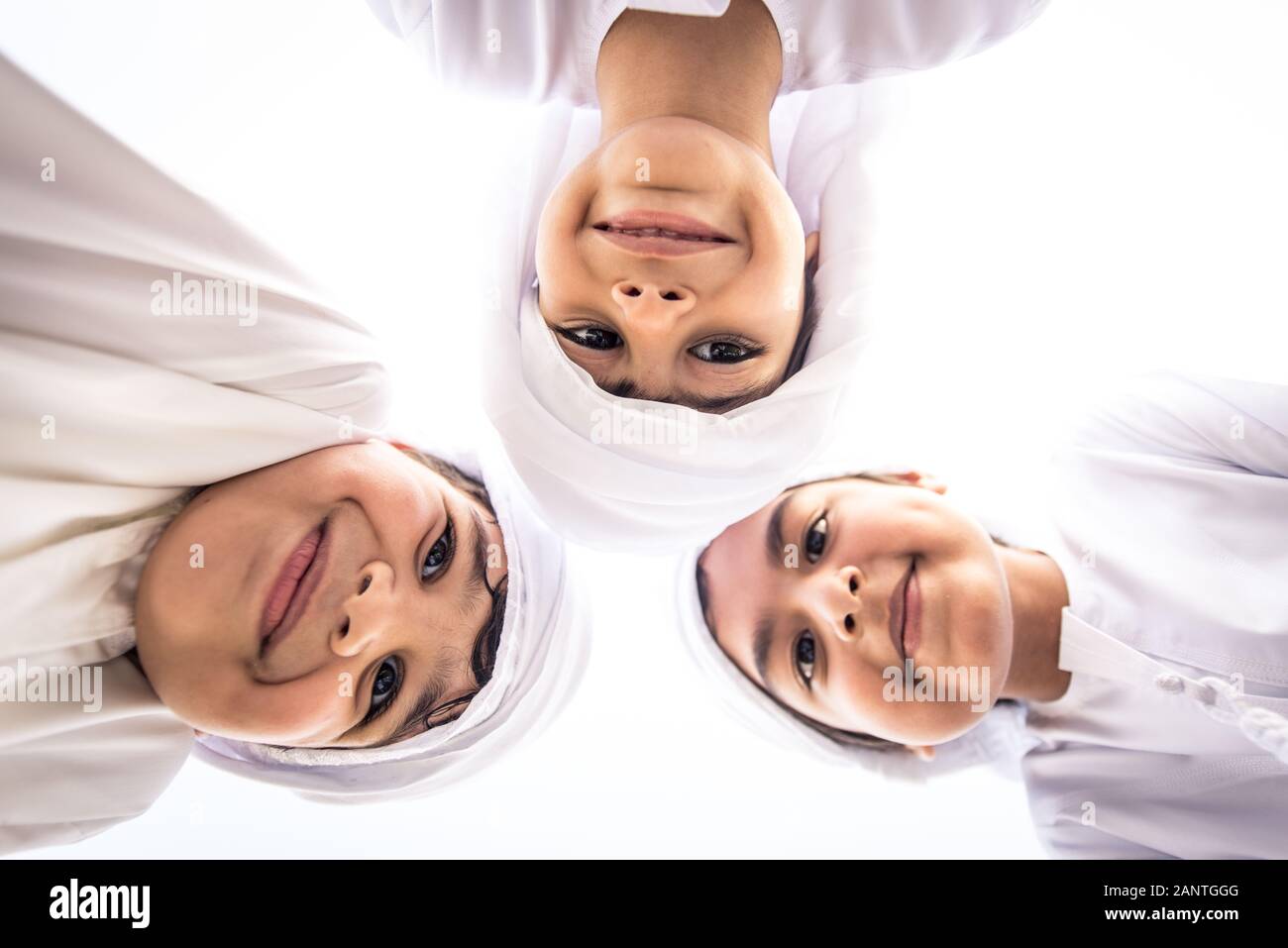 Group of middle-eastern kids wearing white kandora playing in a park in ...