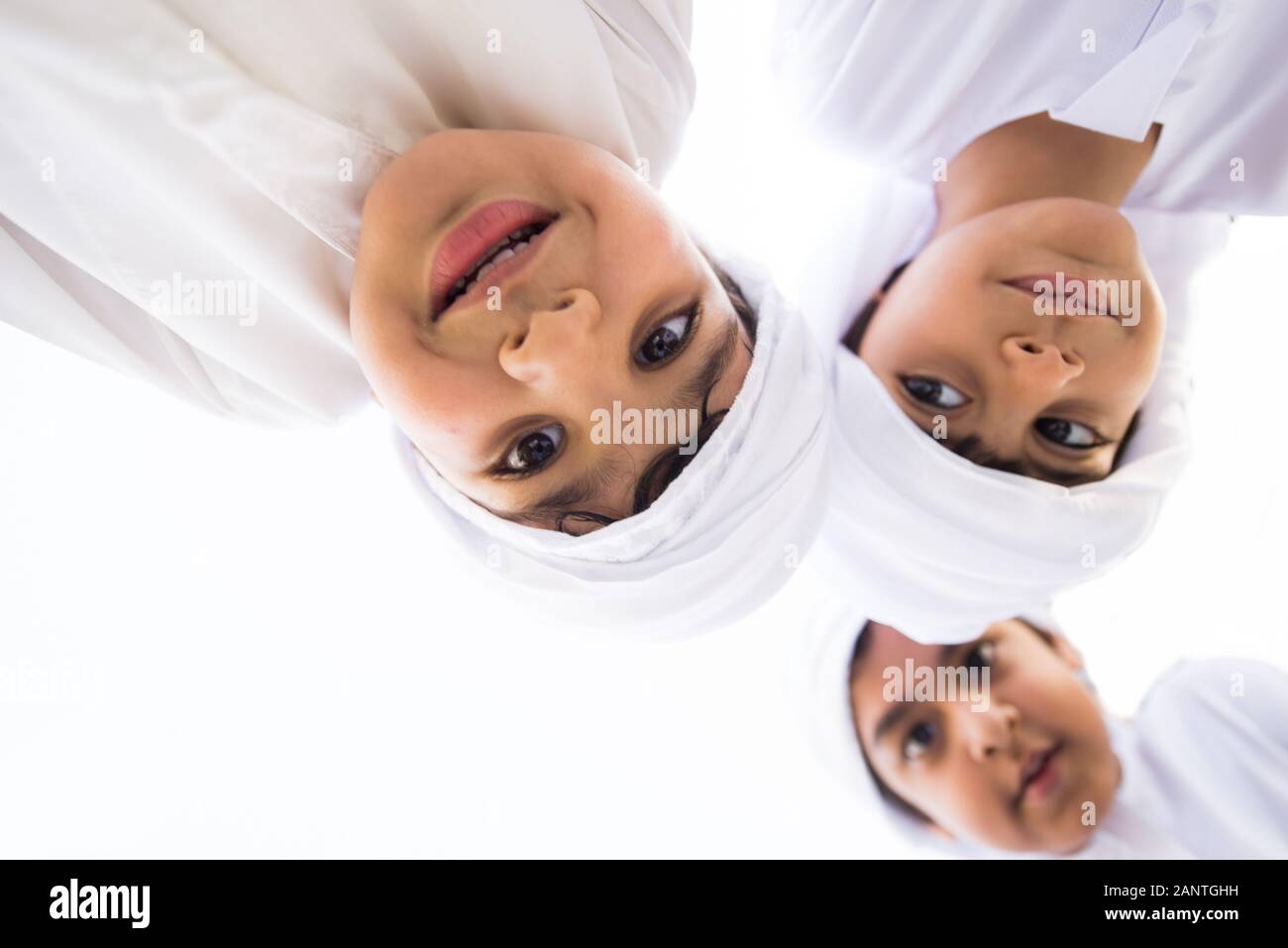 Group of middle-eastern kids wearing white kandora playing in a park in ...