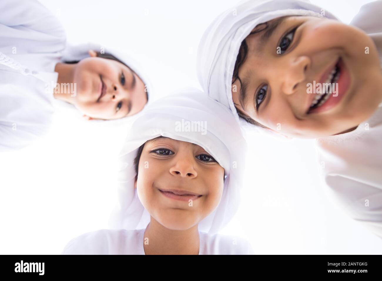 Group of middle-eastern kids wearing white kandora playing in a park in ...