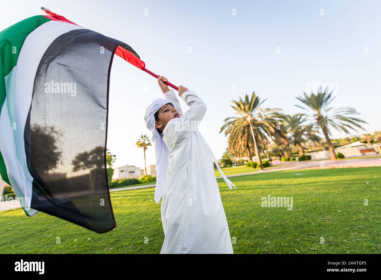 Group of middle-eastern kids wearing white kandora playing in a park in ...