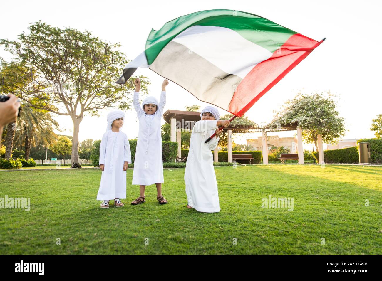 Group of middle-eastern kids wearing white kandora playing in a park in ...