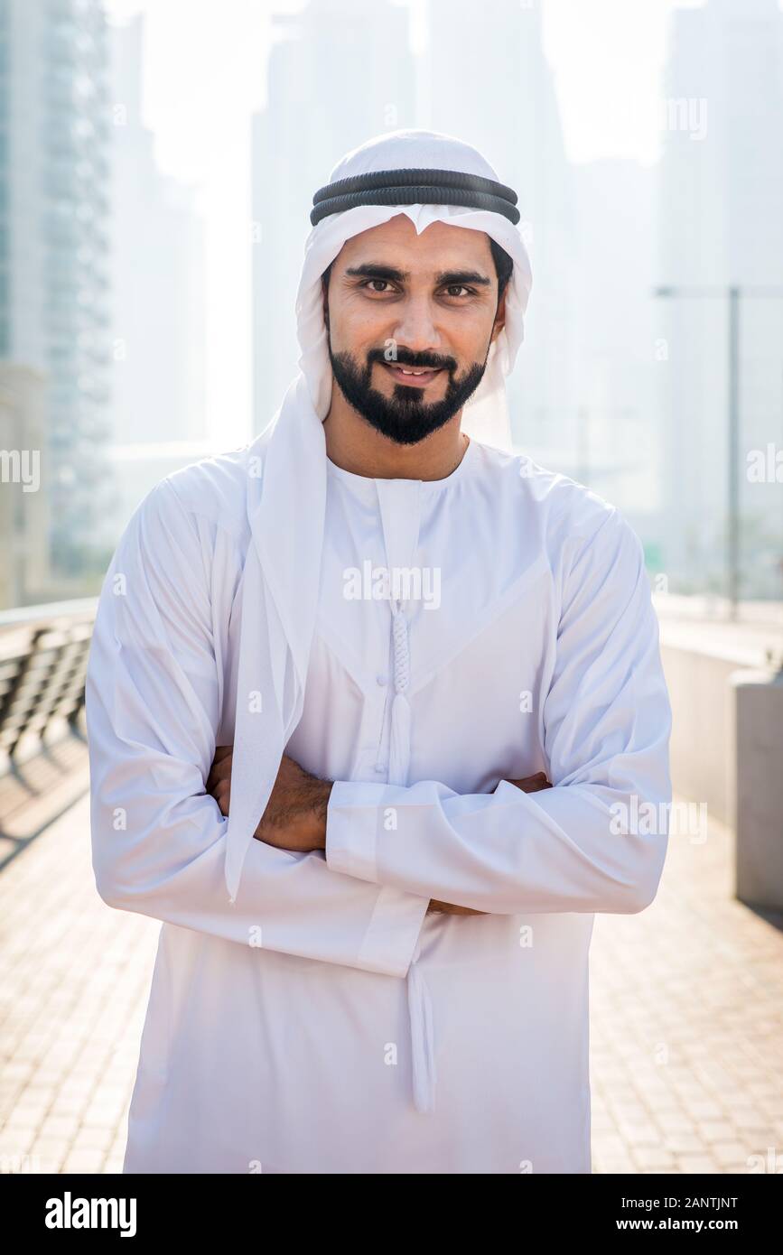 Middle-eastern young adult wearing kandora walking outdoors in Dubai ...