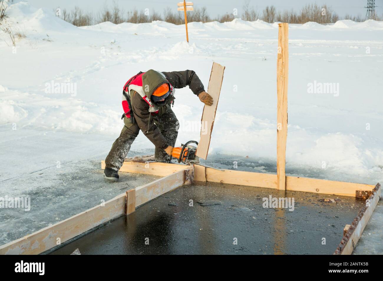 Worker with a chainsaw in the hands of an ice hole Stock Photo - Alamy