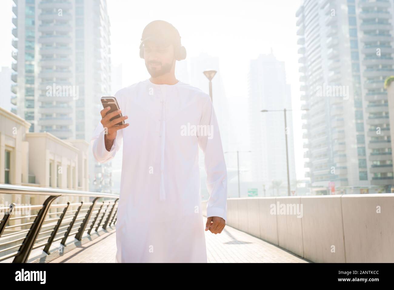 Middle-eastern young adult wearing kandora walking outdoors in Dubai ...