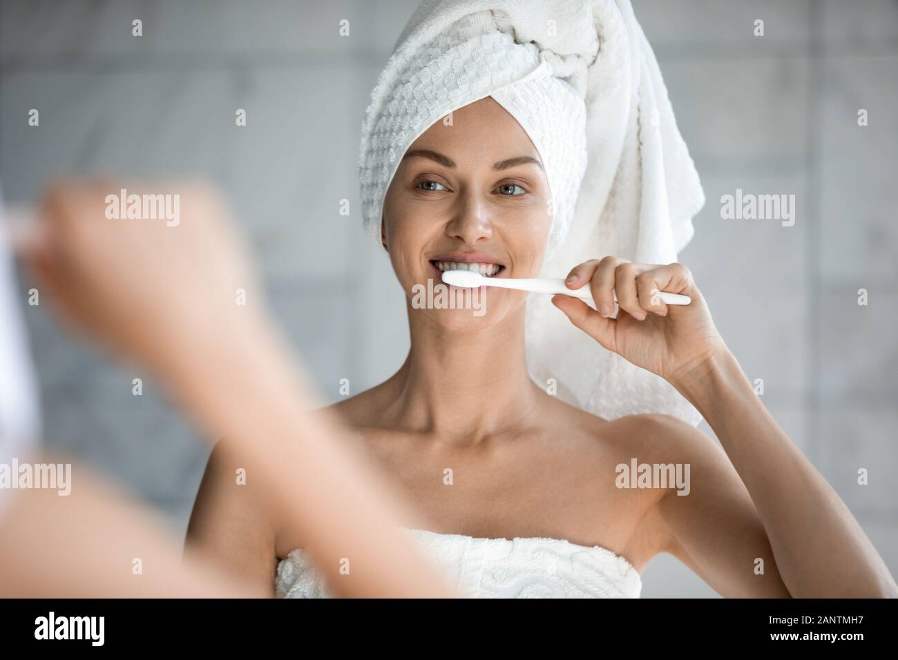 Head shot beautiful woman brushing teeth, looking in mirror Stock Photo ...