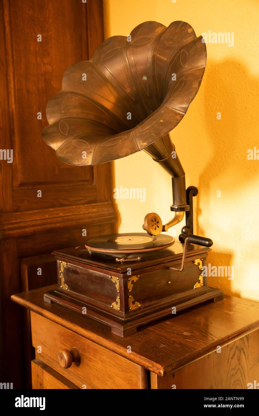 antique gramophone record player against a yellow wall in afternoon ...