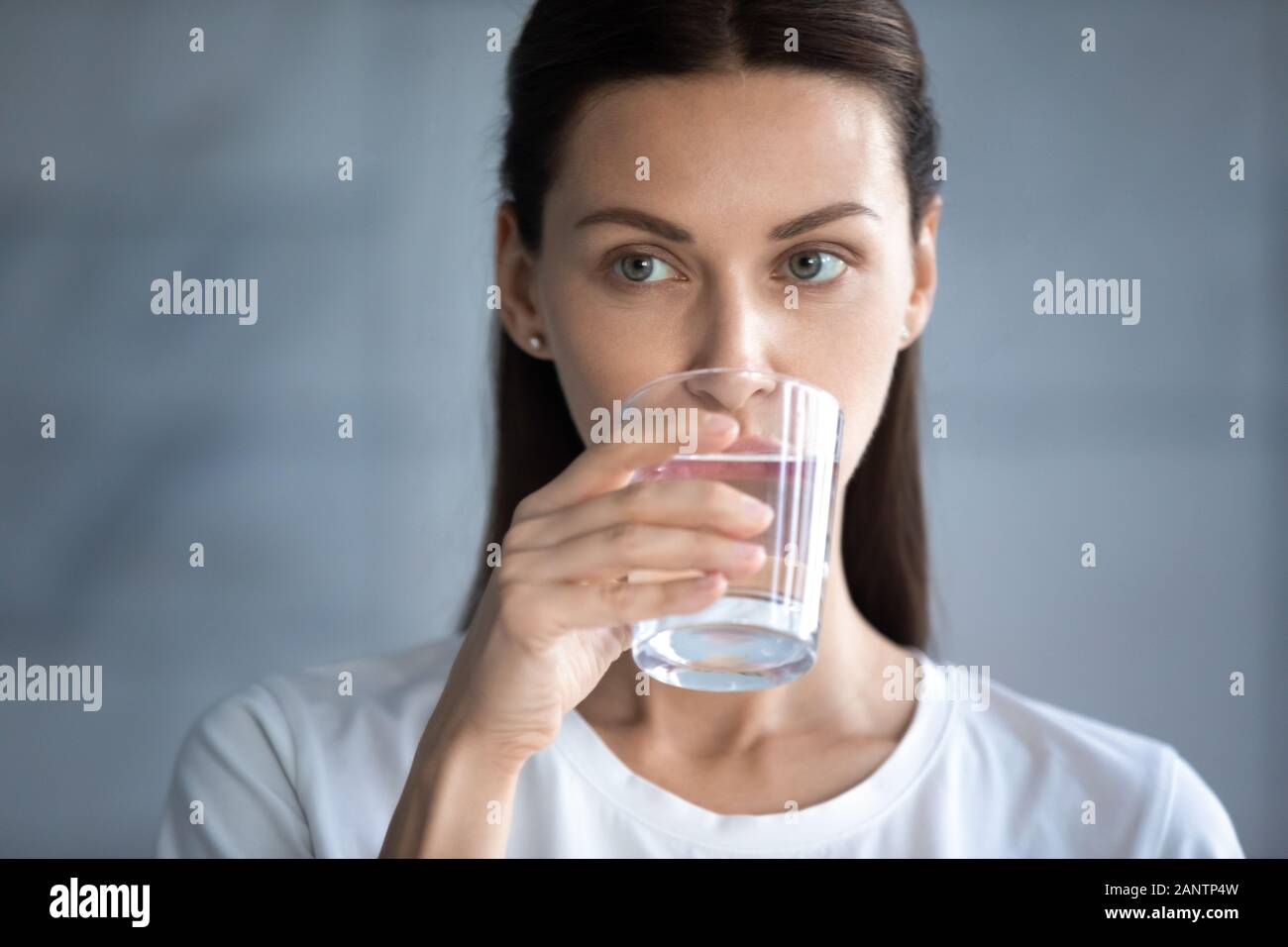 Head shot beautiful woman drinking clean mineral water, holding glass ...