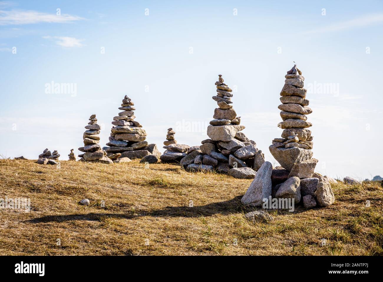 Many man-made granite stone stacks (called cairns) on the coastal path ...