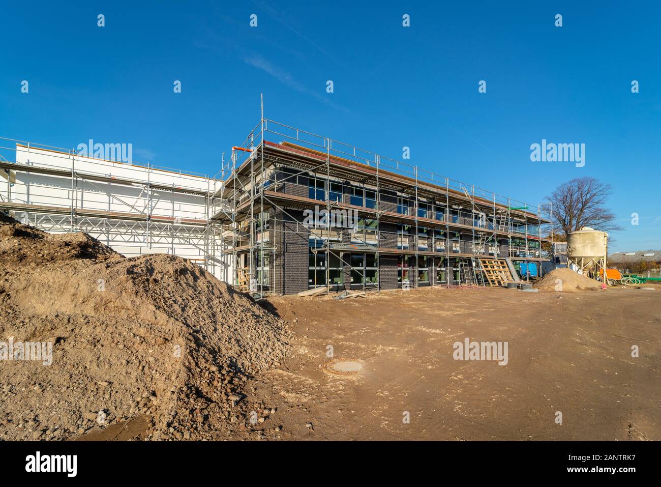An office building on a construction site that is completely scaffolded ...