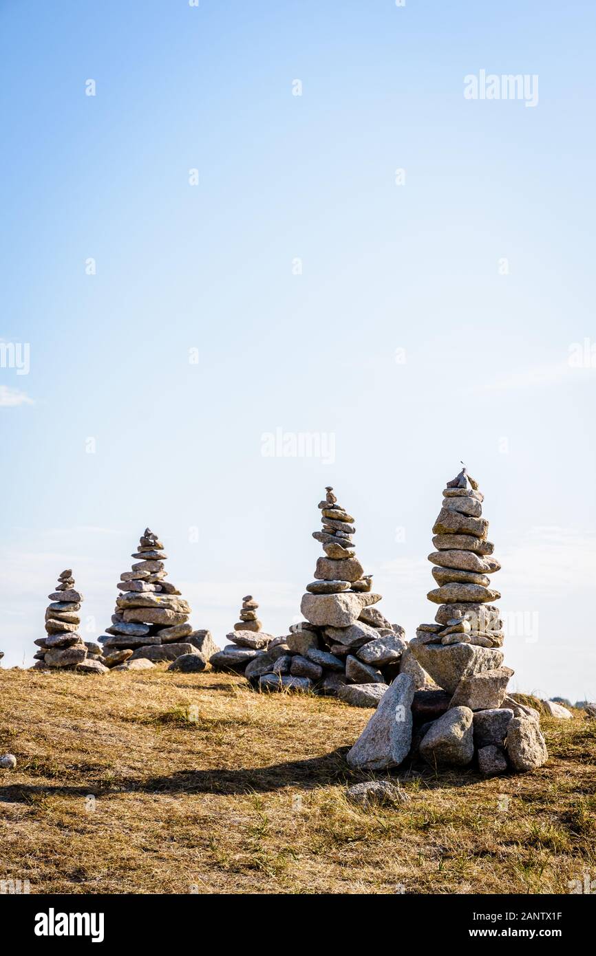 Many man-made granite stone stacks (called cairns) on the coastal path ...