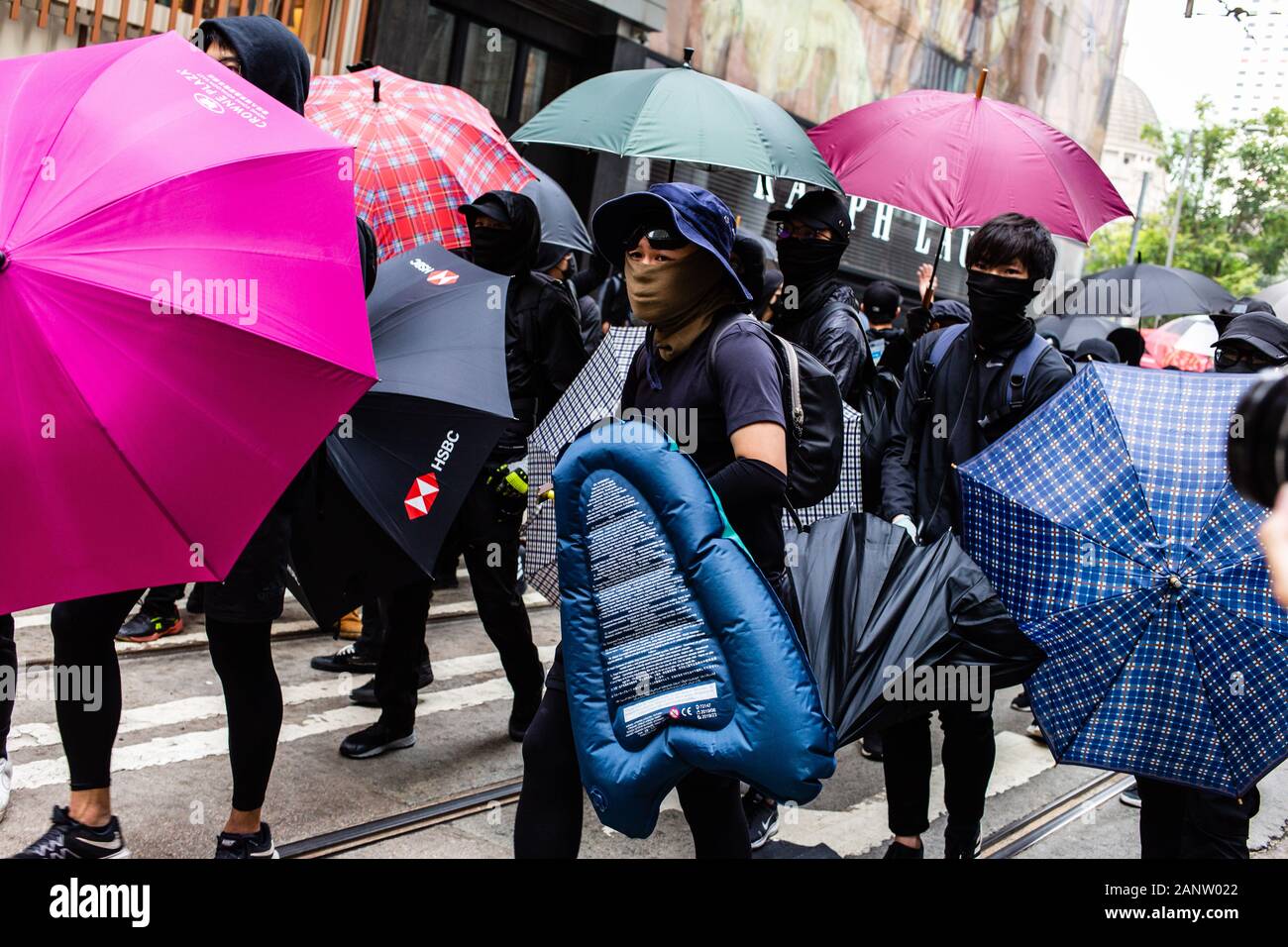 Protesters shield themselves with umbrellas during the rally.Entering ...