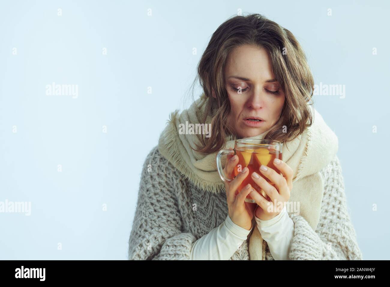 sad sick modern female in roll neck sweater and cardigan holding cup of ...