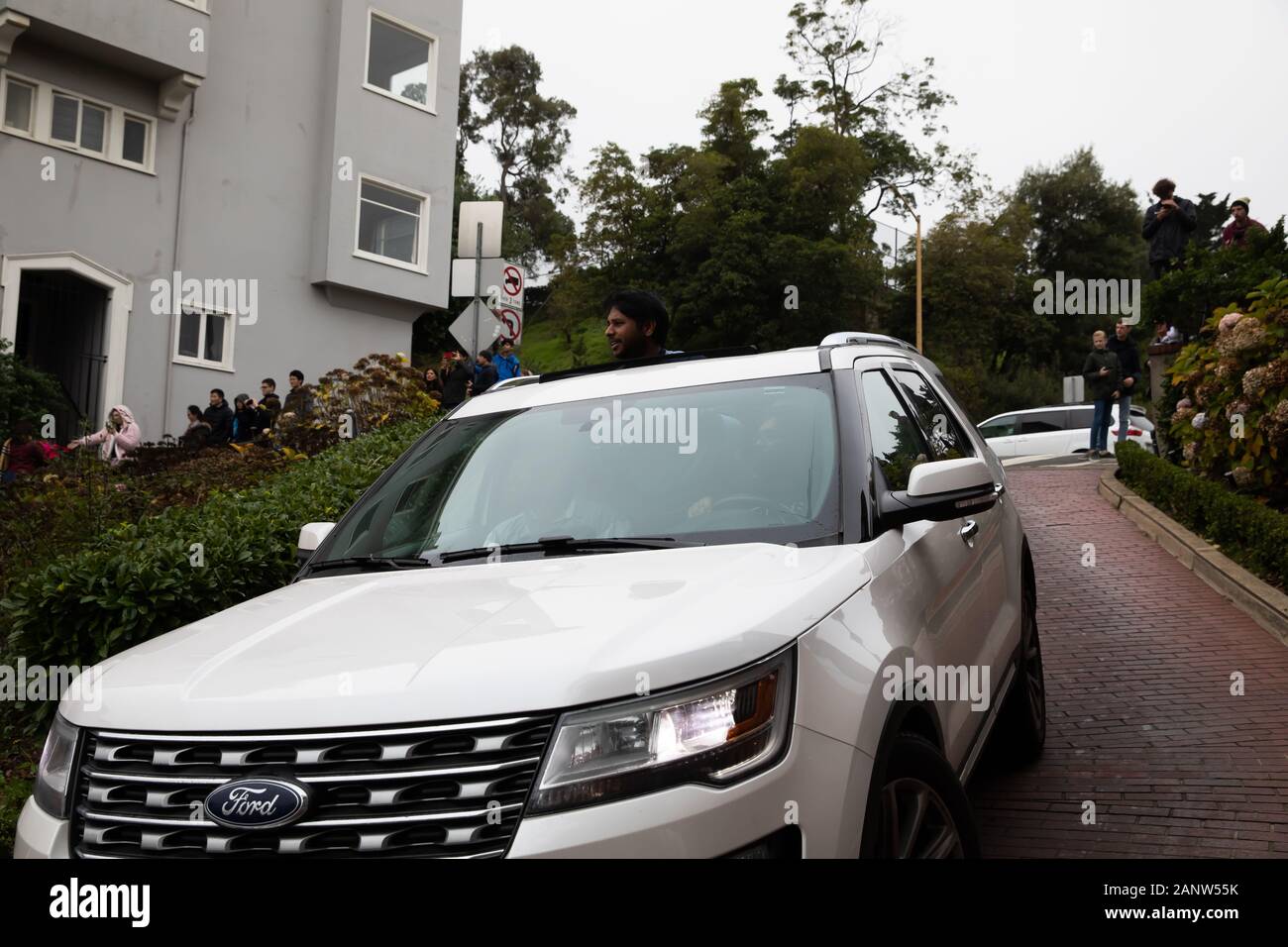 Cars drive slowly down Lombard Street, known as the crookedest street ...