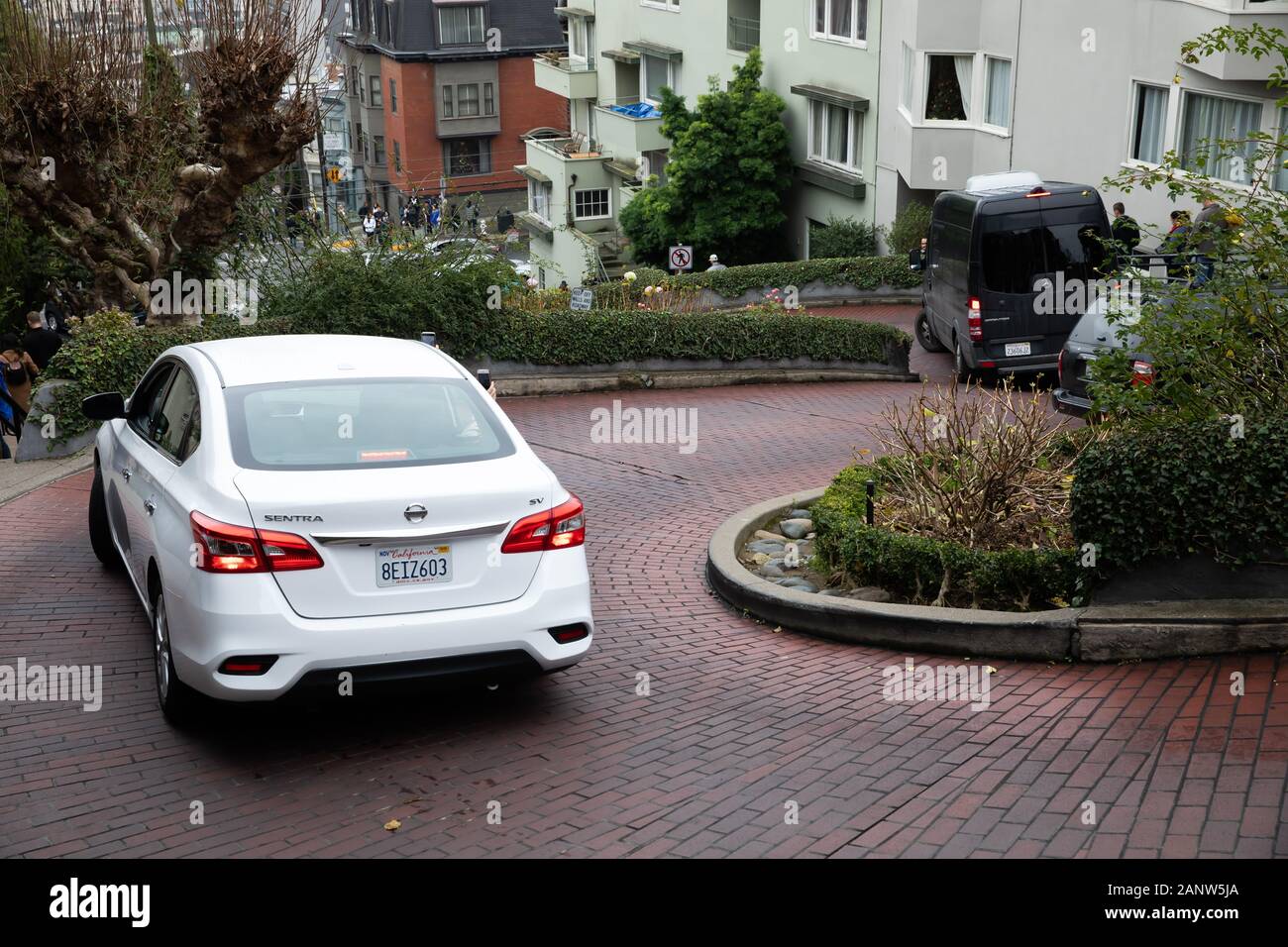 Cars drive slowly down Lombard Street, known as the crookedest street ...