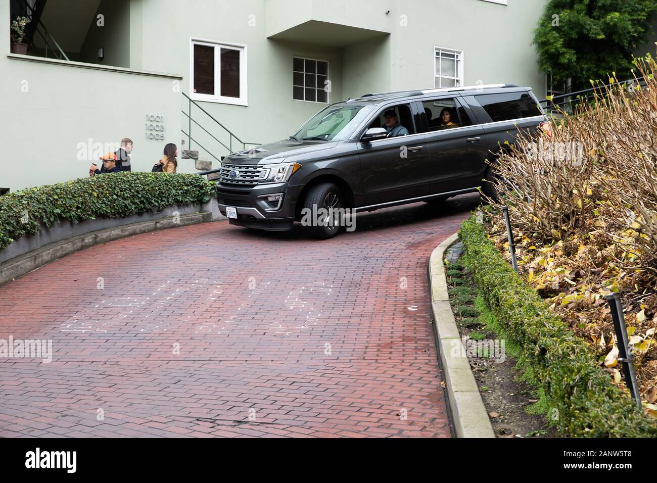 Cars drive slowly down Lombard Street, known as the crookedest street ...