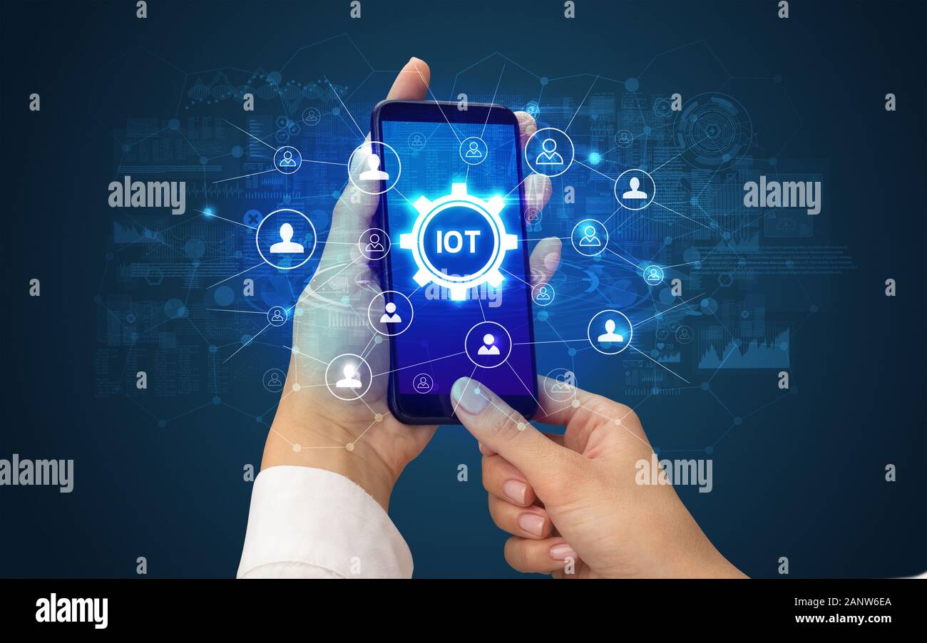 Female hand holding smartphone with IOT abbreviation, modern technology ...