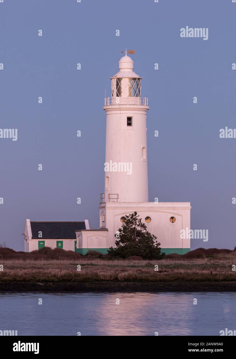 White lighthouse and associated buildings next to still water Stock ...