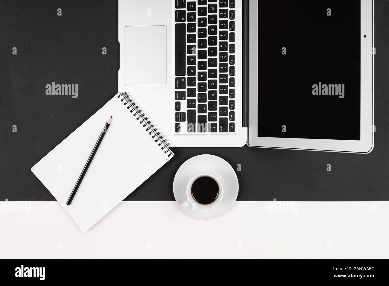 Desktop with laptop, note, pen isolated on black and white background ...
