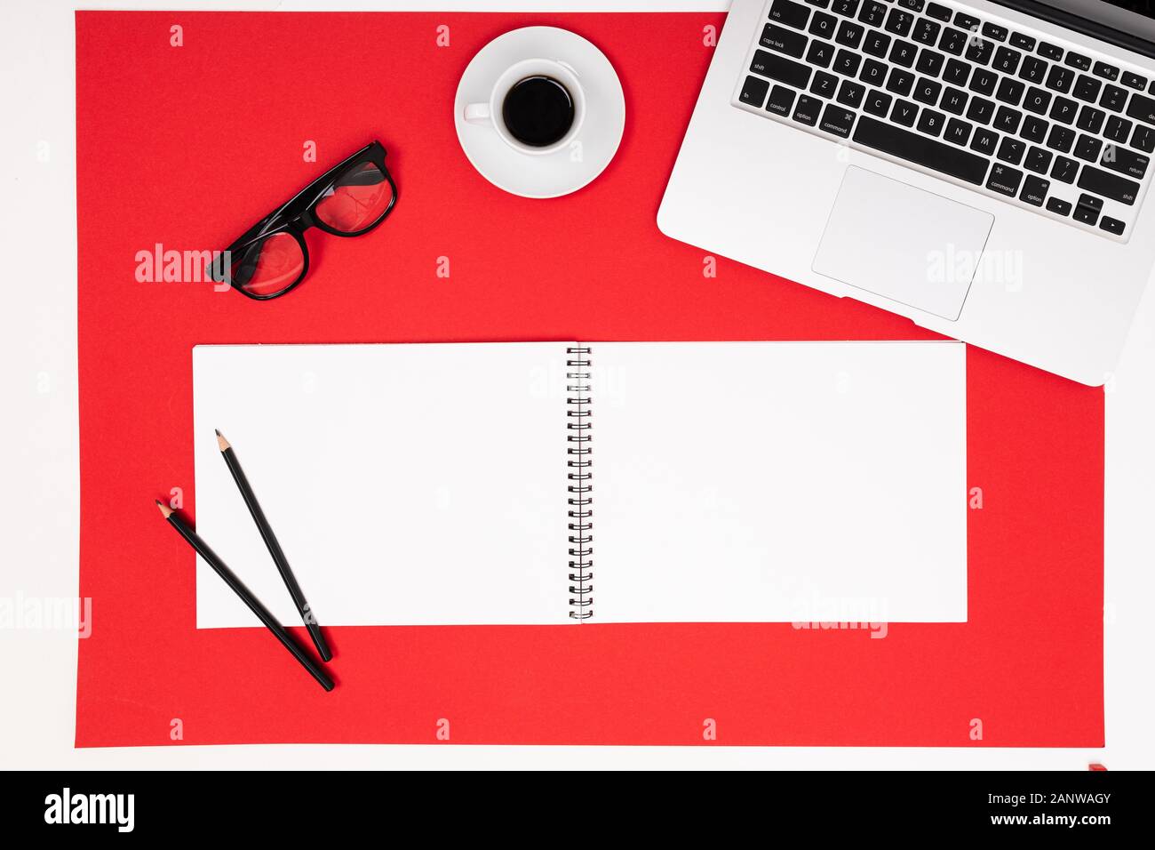 office workplace with notepad with mockup, laptop and pencil on red ...