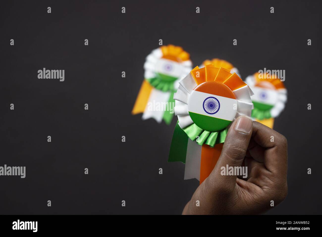 Hand holding Indian flag badges on black background, tricolor, saffron ...