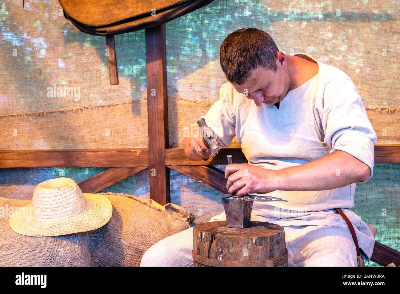 A blacksmith makes a nail. Forge in the open air during the living ...