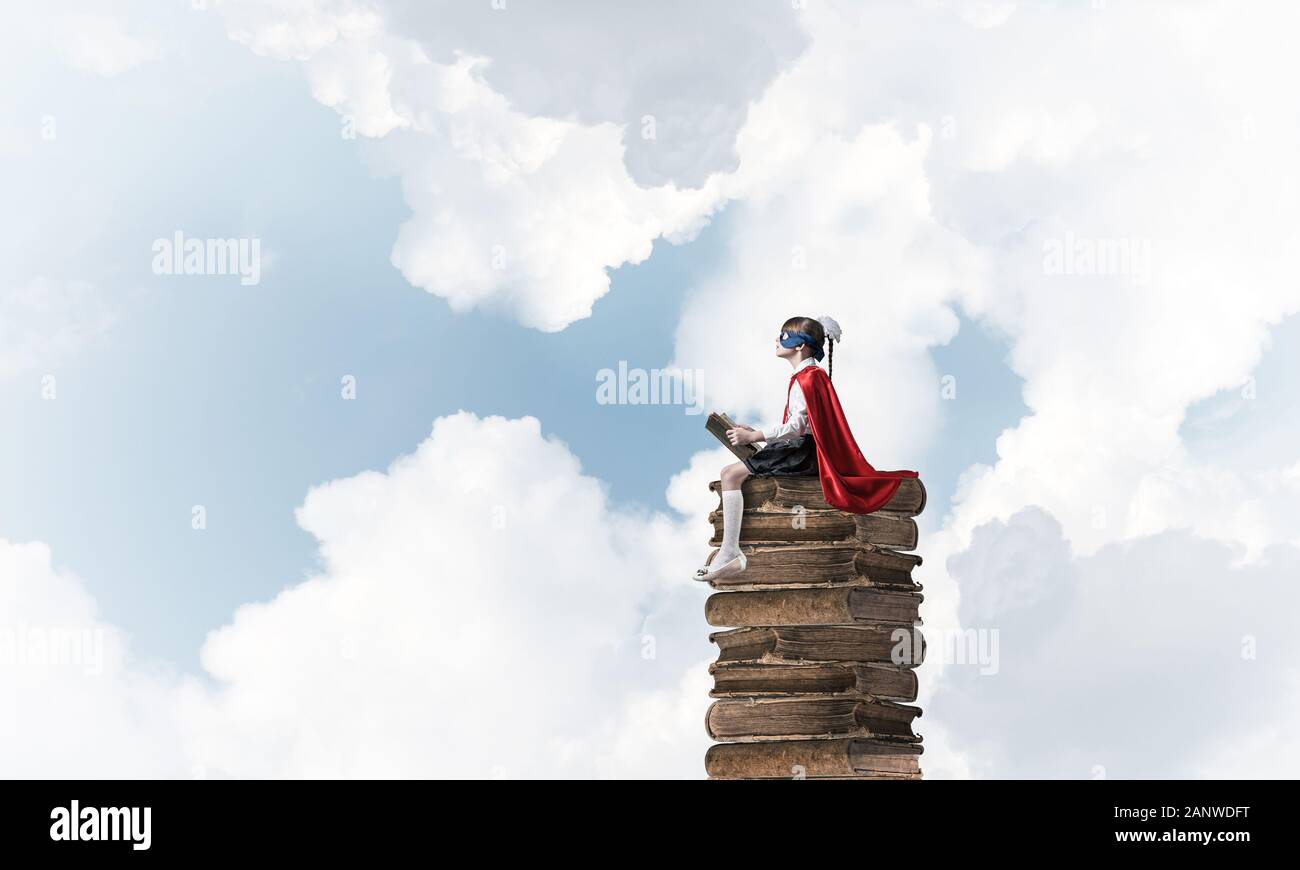 Girl power concept with cute kid guardian against cloudscape background ...