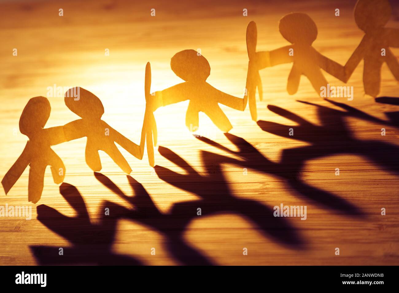 Team of paper chain people in a row holding hands Stock Photo - Alamy