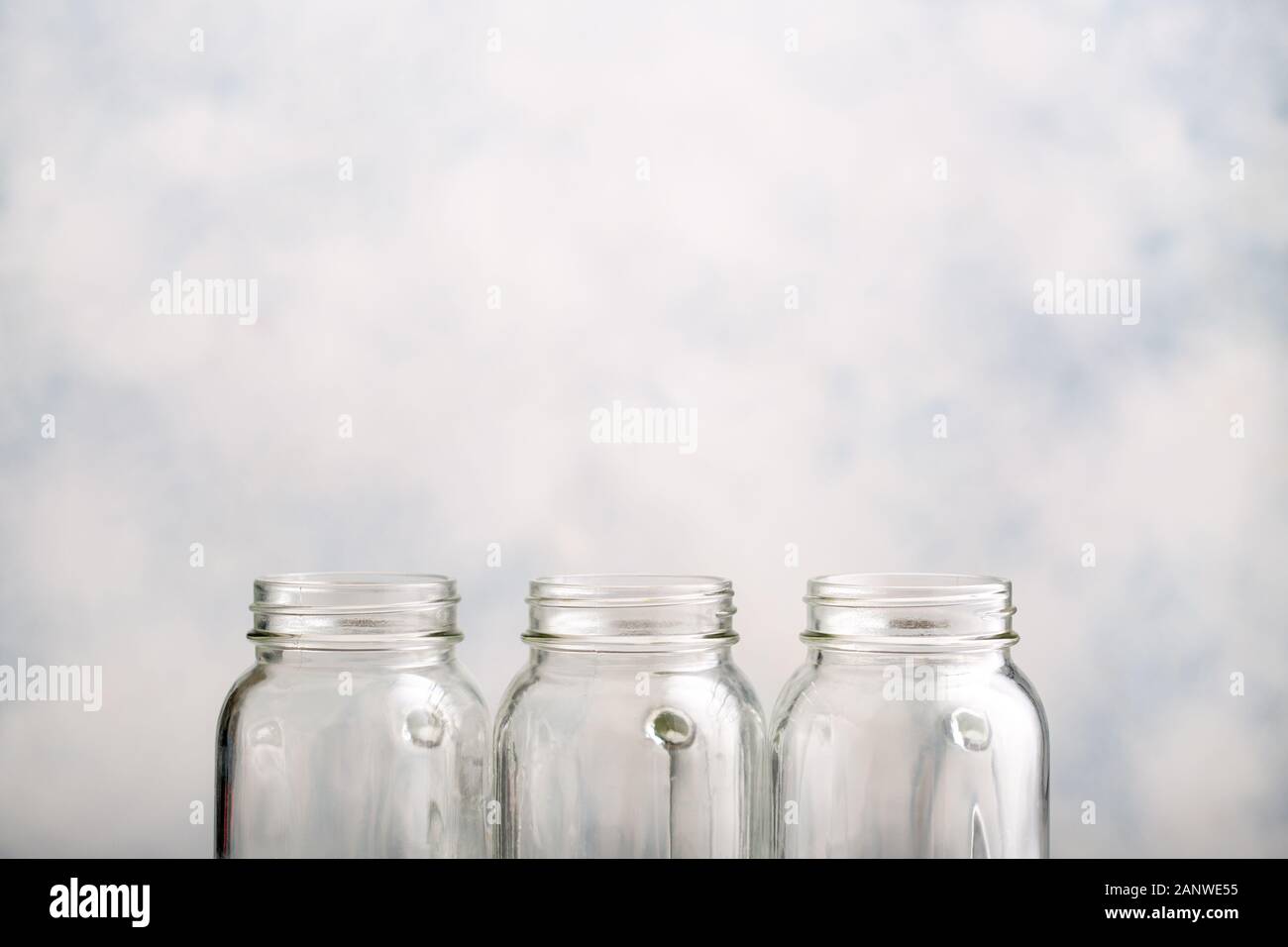 Three empty clean canning jars with drops of water. Three empty clean ...
