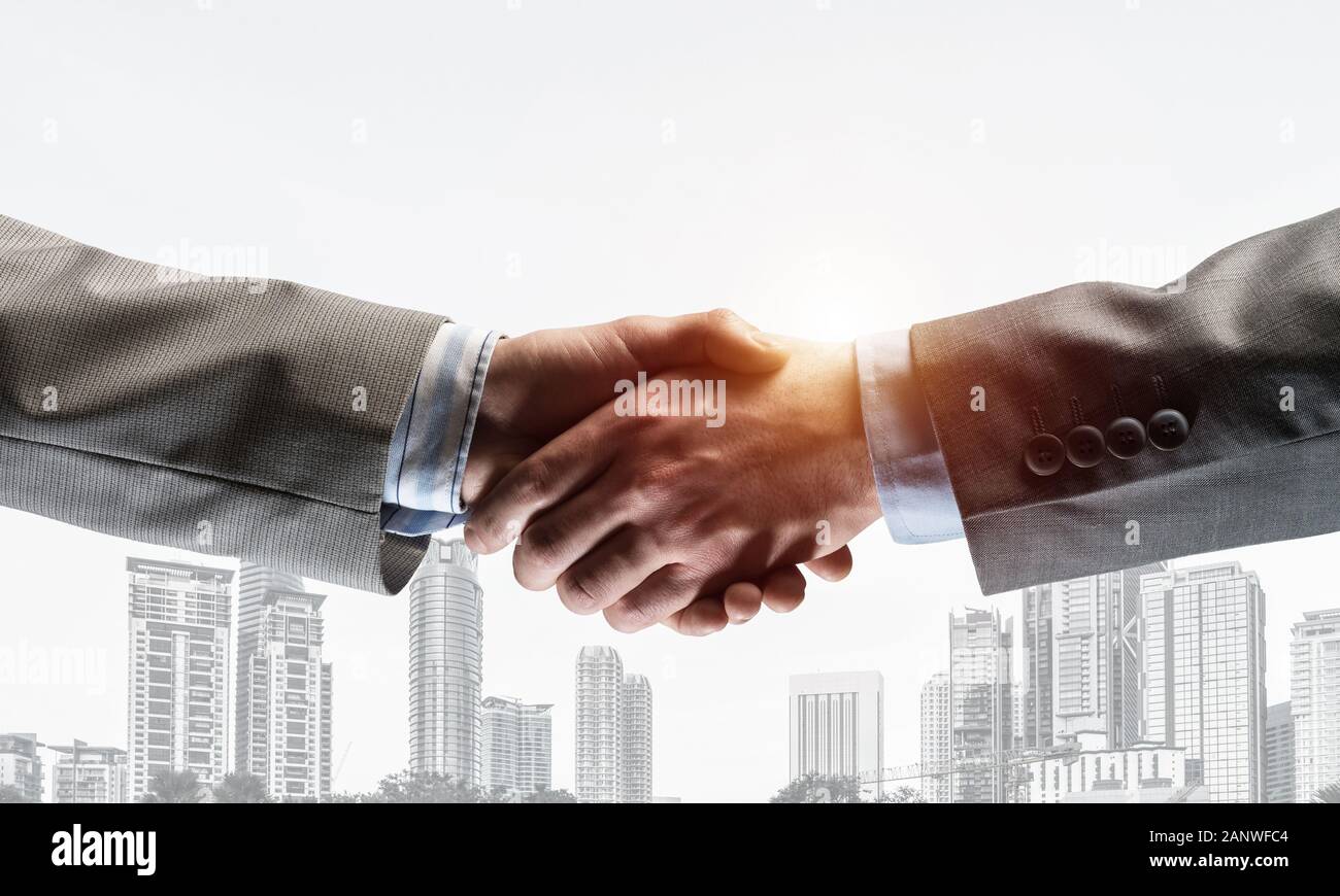 Business handshake as idea for unity and cooperation or greeting. Mixed ...