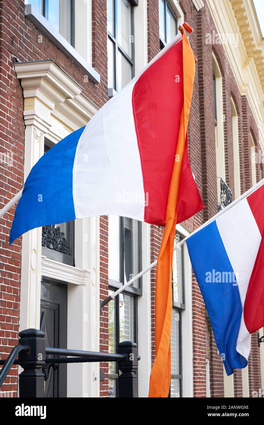 Dutch flags with orange streamer waving in the wind on facades of ...