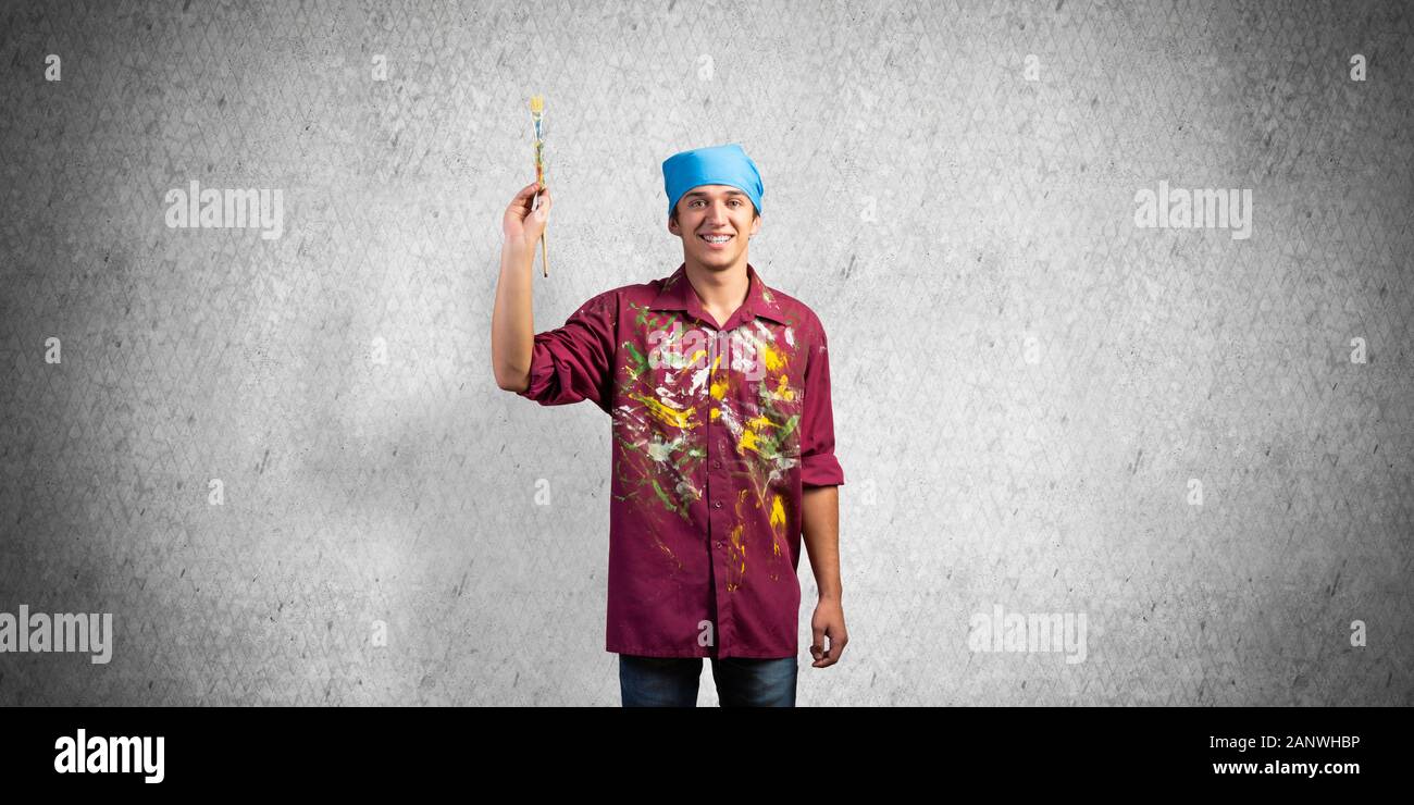 Smiling young painter artist pointing upwards Stock Photo - Alamy