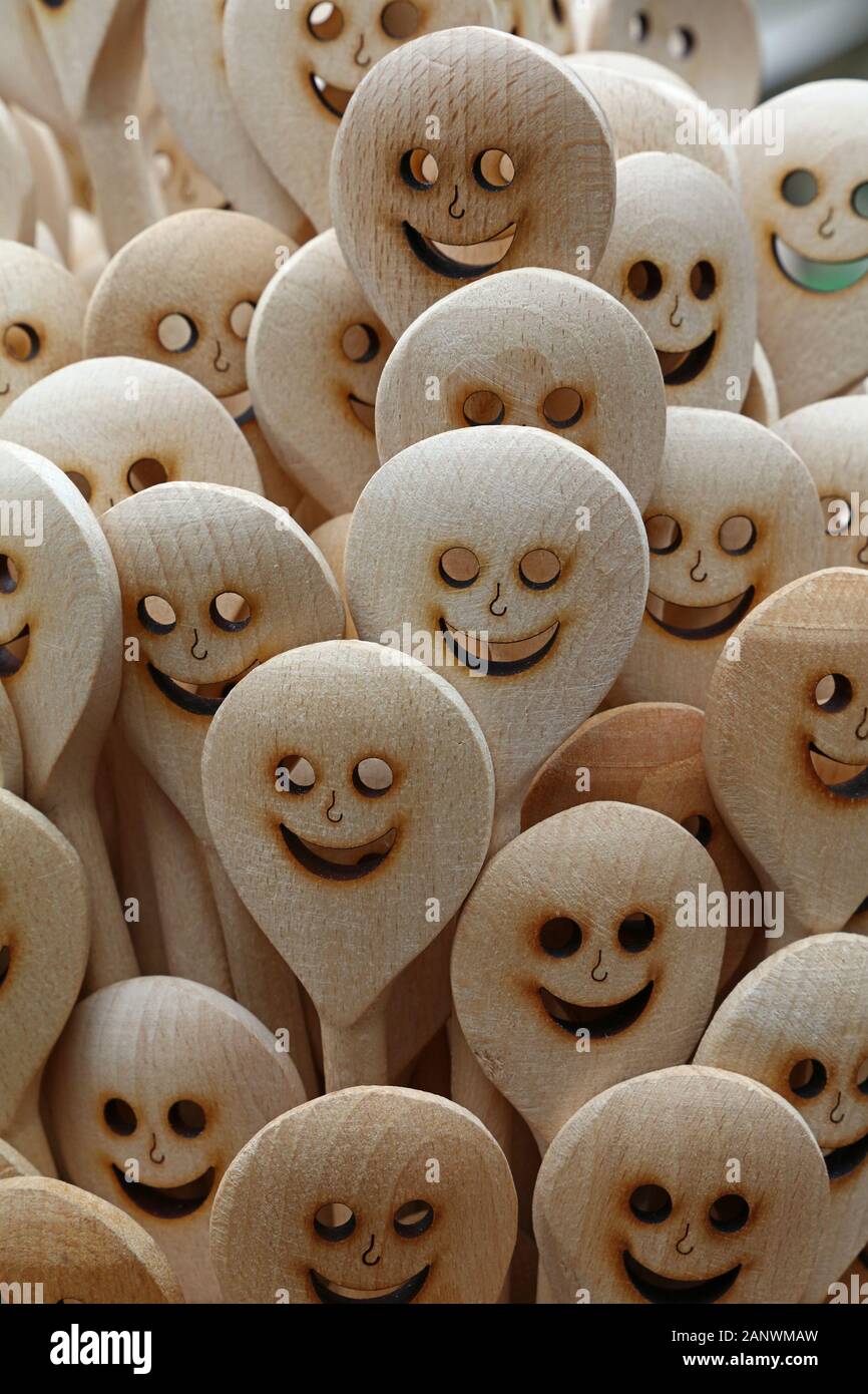 Close up handmade rustic wooden cooking spoons with carved happy ...