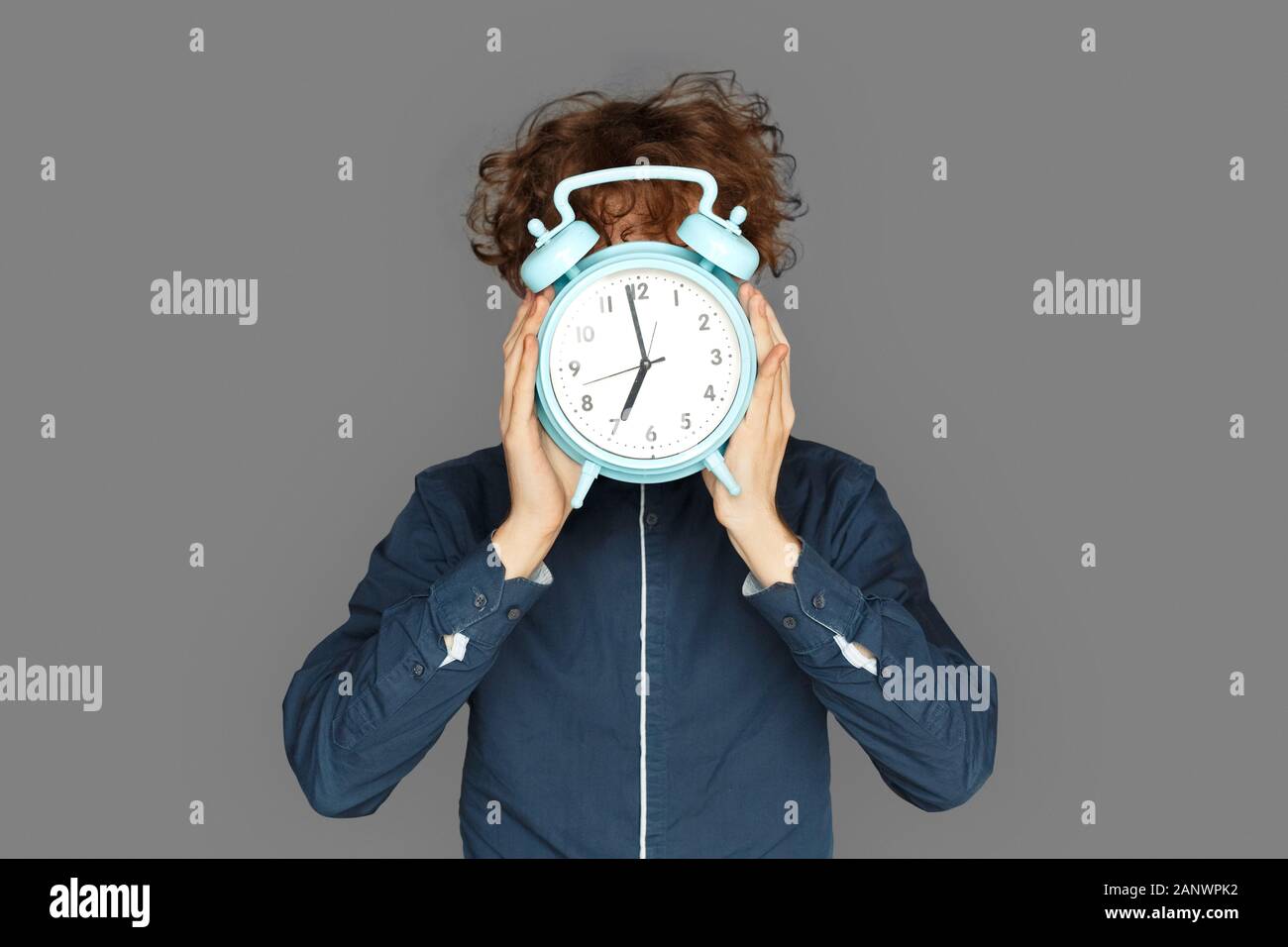 Showing Time. Teenager boy standing isolated on grey covering face with ...