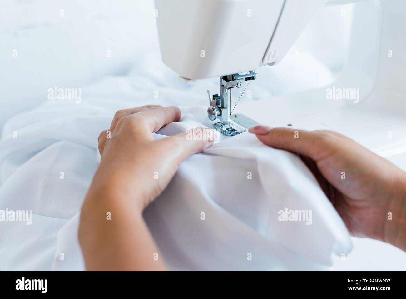 Adjusting fabric under needle of sewing machine Stock Photo - Alamy
