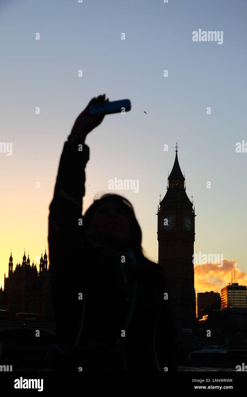 Silhouette of girl taking selfie with Big Ben in background at sunset ...