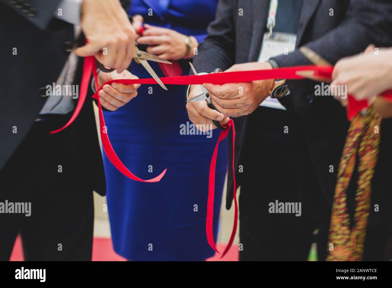 Process of cutting the red ribbon during the grand opening of the new ...