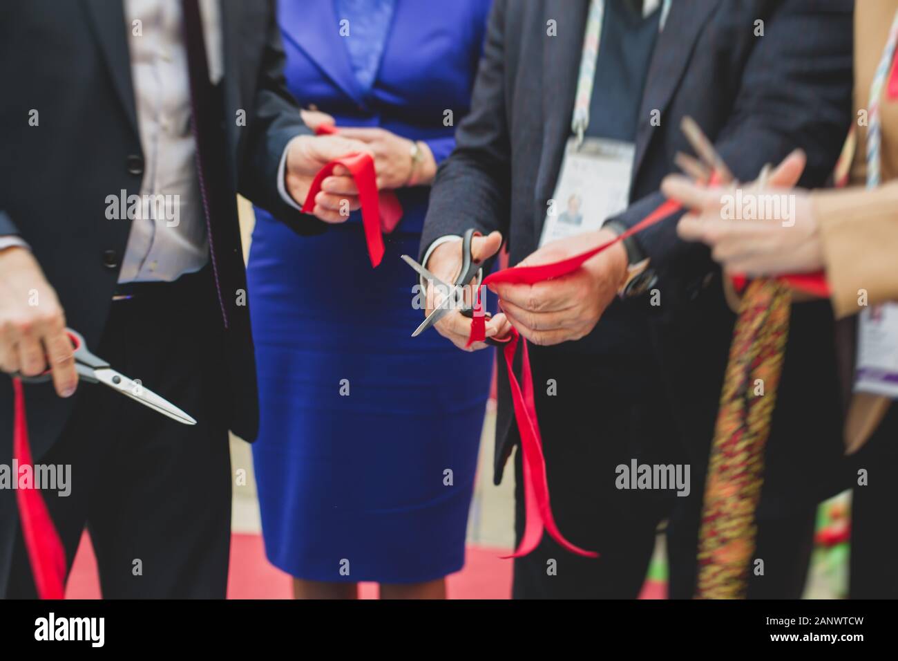 Process of cutting the red ribbon during the grand opening of the new ...